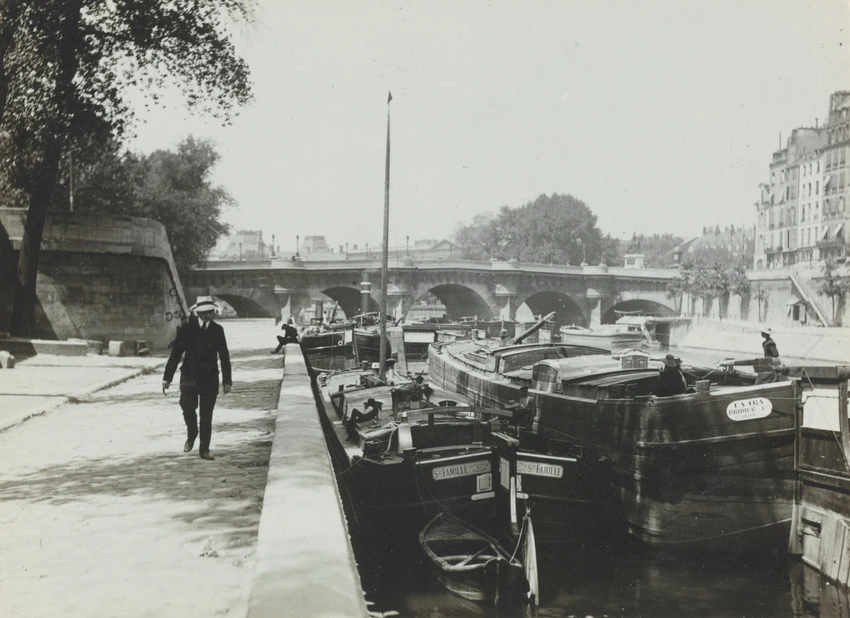 Paris, homme marchant sur un quai près de péniches amarrées devant le ...