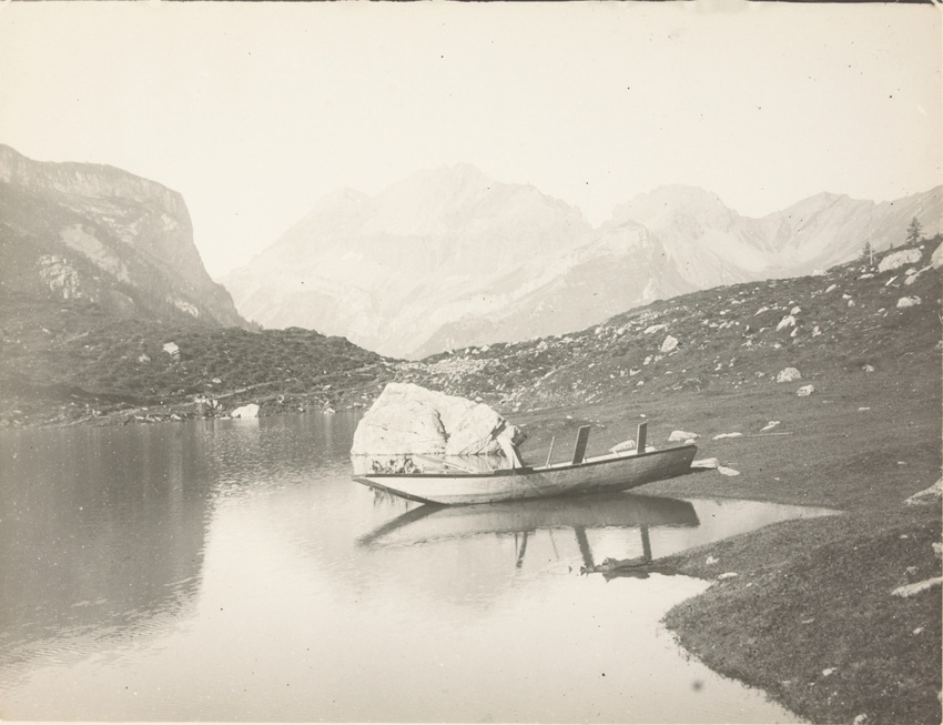 Paysage de montagne avec une barque sur un lac au premier plan ...